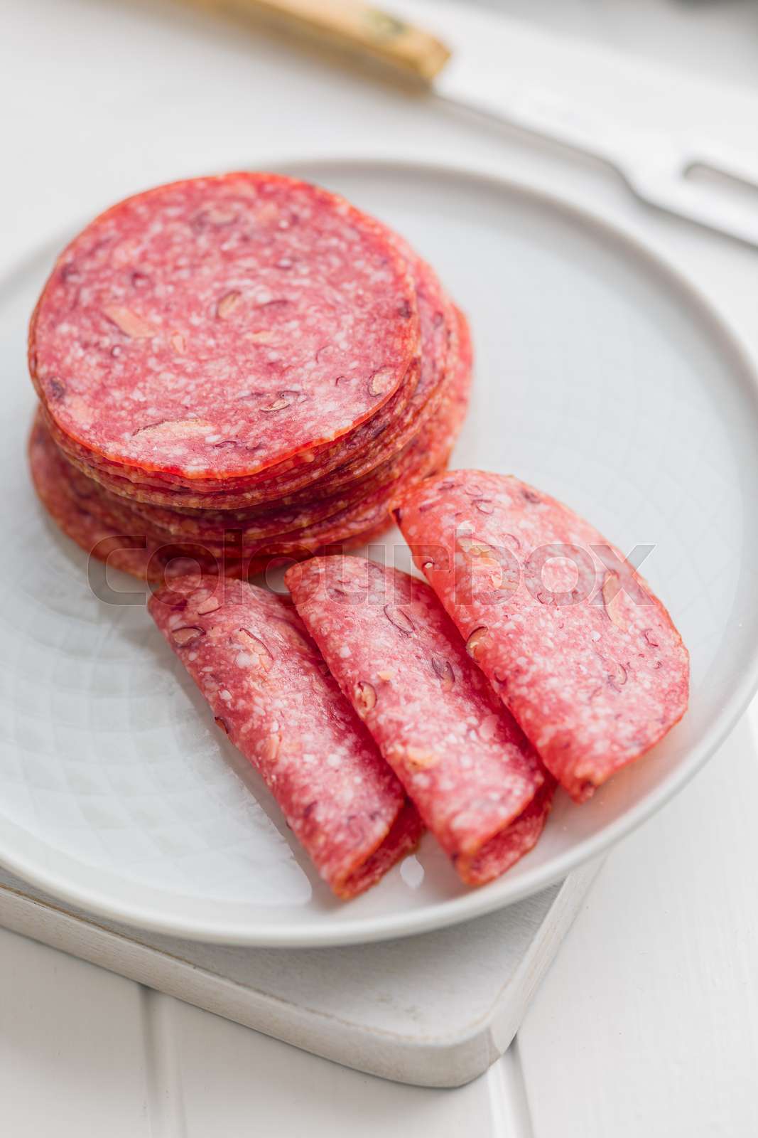 Sliced mexican salami with beans on plate. | Stock image | Colourbox