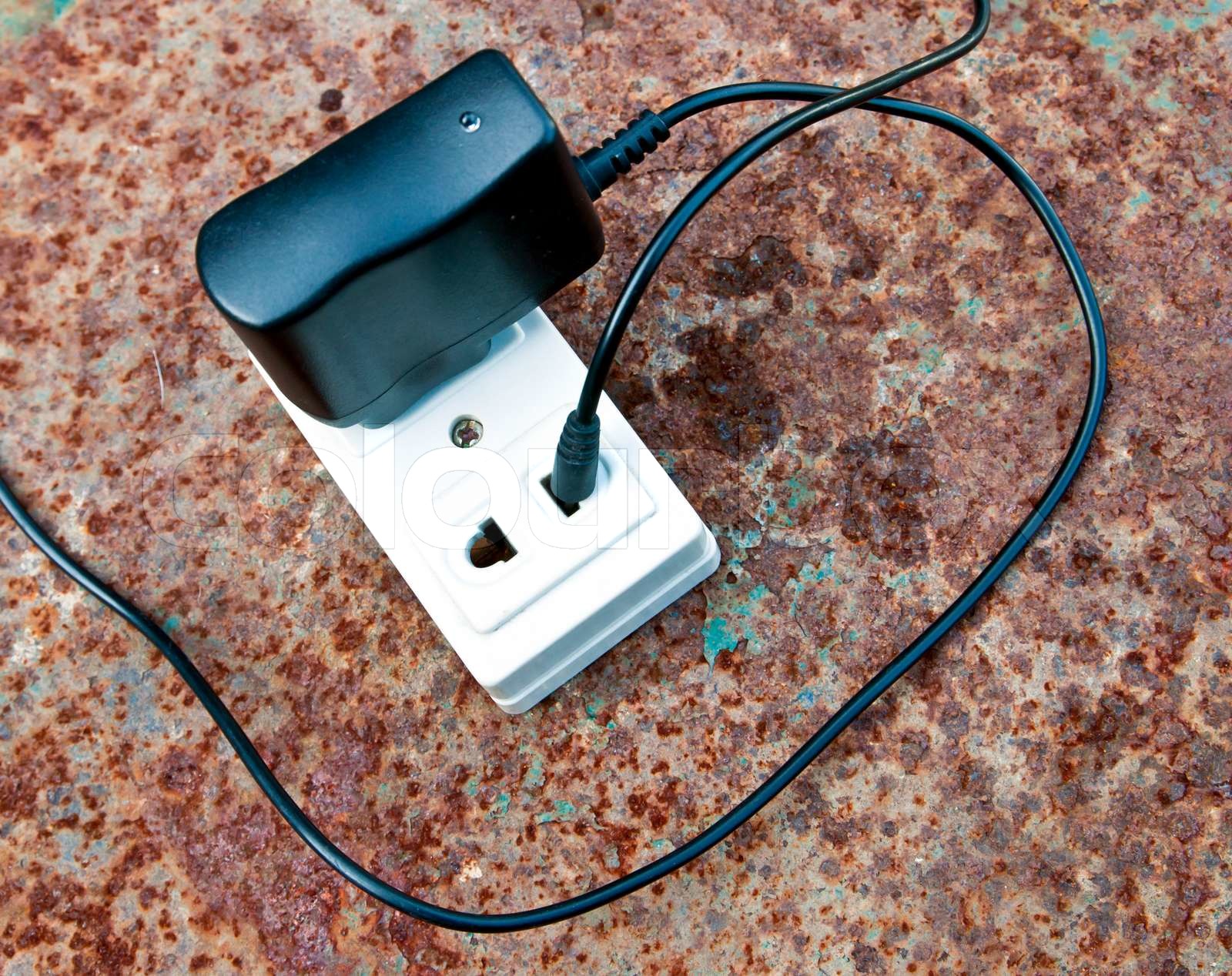 black cable plugged in a white electric outlet | Stock image | Colourbox
