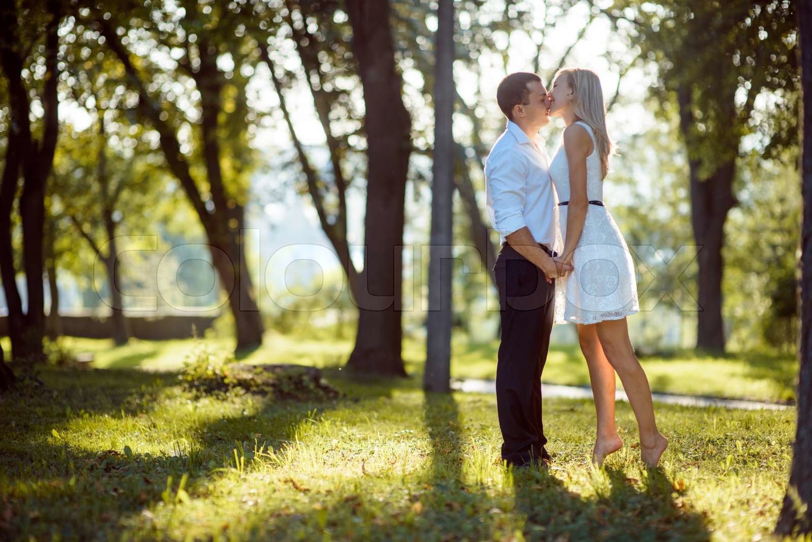 Forelsket par kysser i en park | Stock foto | Colourbox