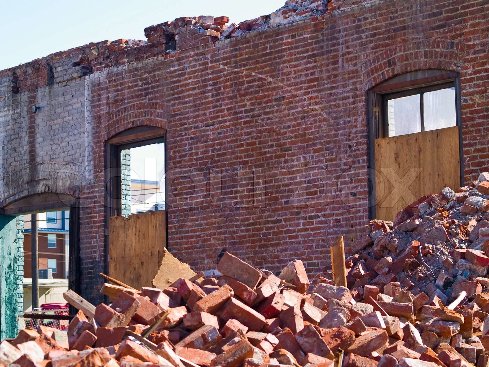 A demolition site with a pile of demolished brick wall and concrete ...