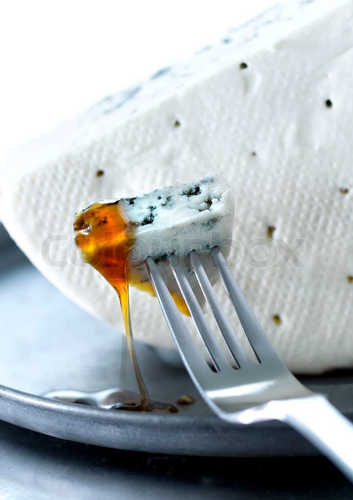 Nærbillede af en gaffel med ost og honning | Stock foto | Colourbox