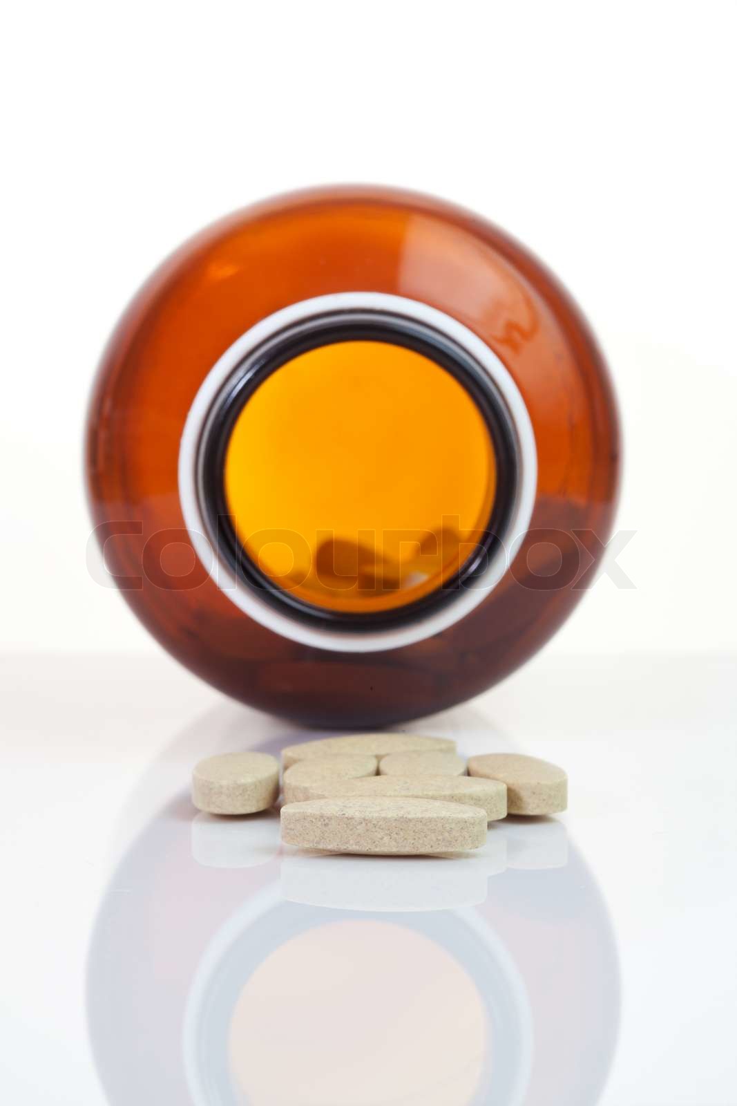 Open pill bottle with medicine spilling out | Stock image | Colourbox
