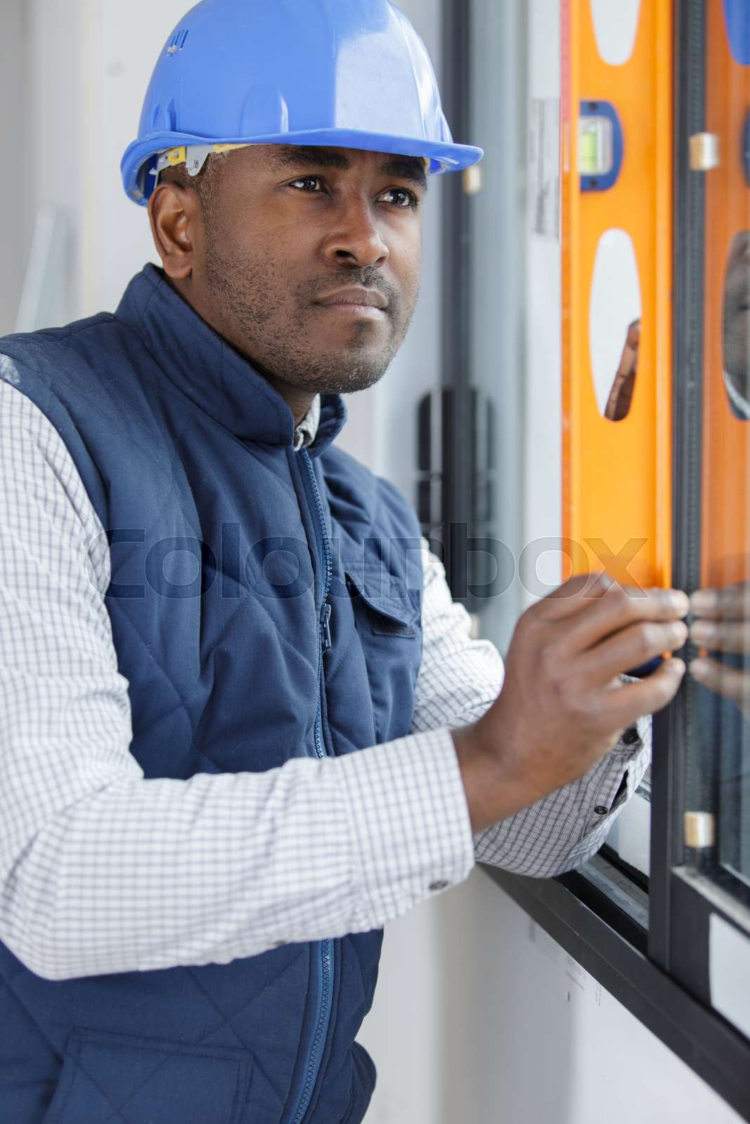 builder measuring window level with spirit level | Stock image | Colourbox