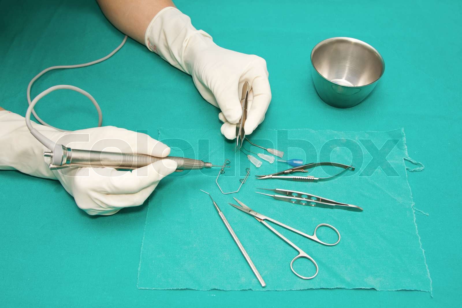 set of eye surgical instrument on sterile table with a hand of doctor ...