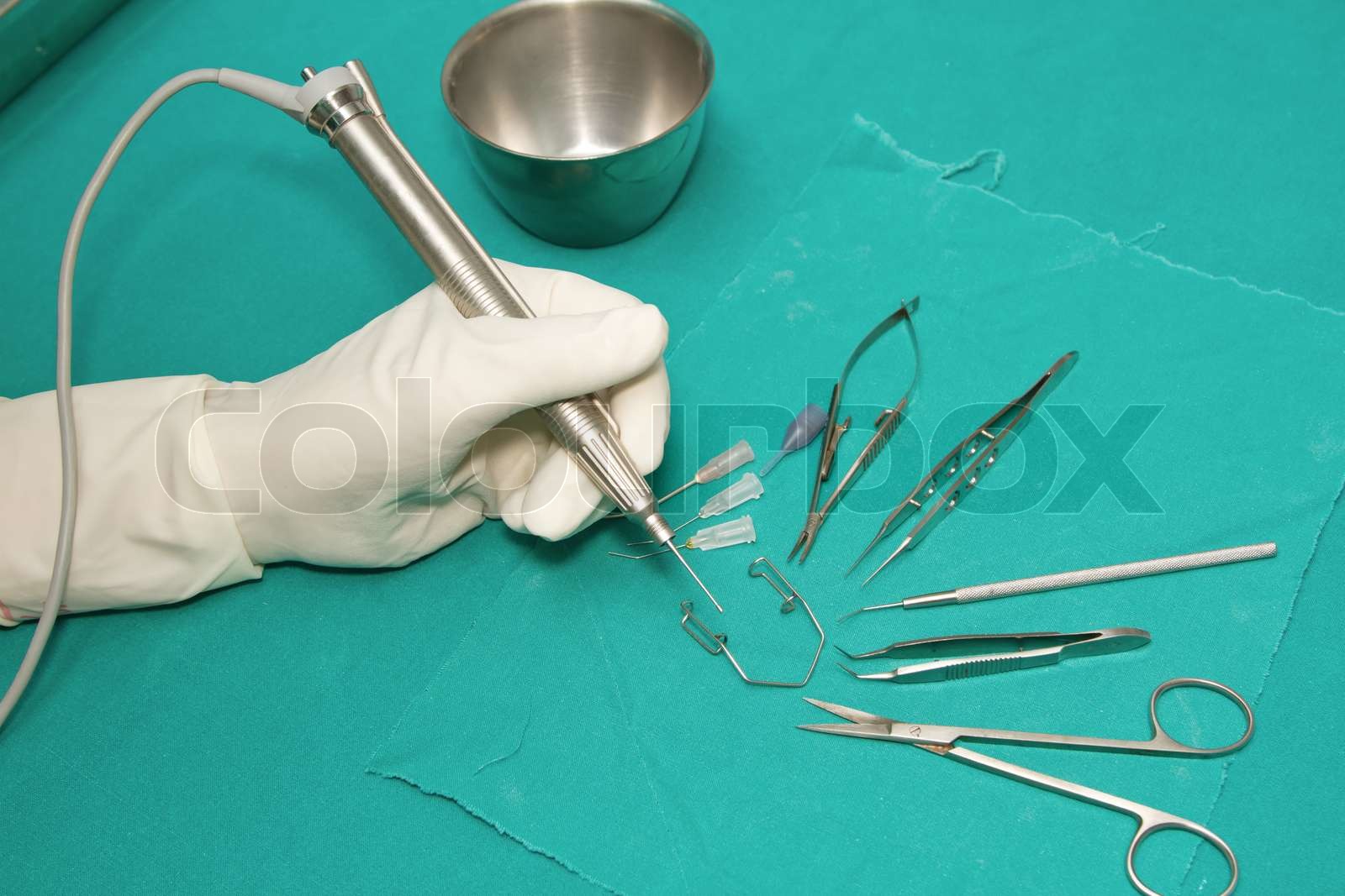 set of eye surgical instrument on sterile table with a hand of doctor ...