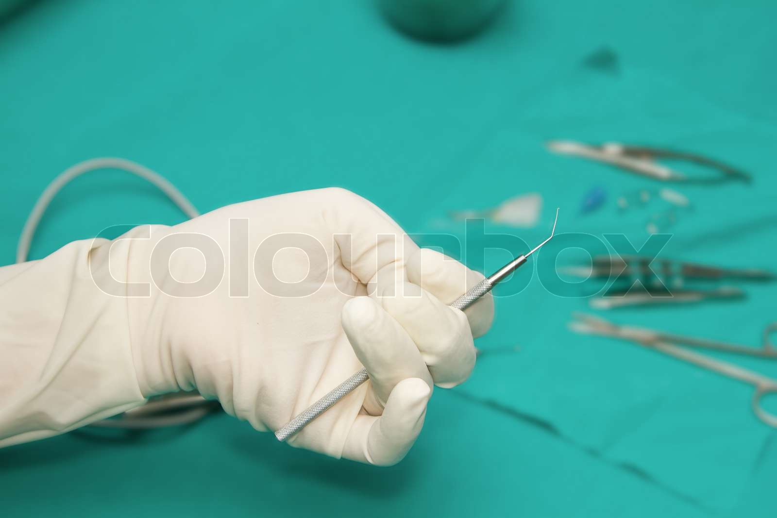 set of eye surgical instrument on sterile table with a hand of doctor ...