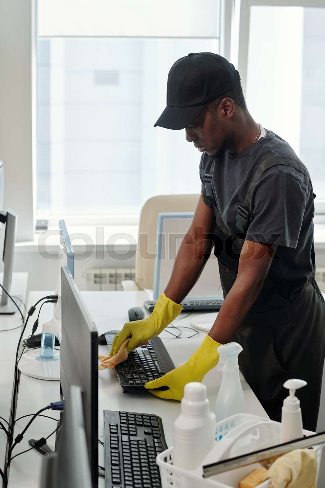 African American male staff of cleaning company wiping computer ...