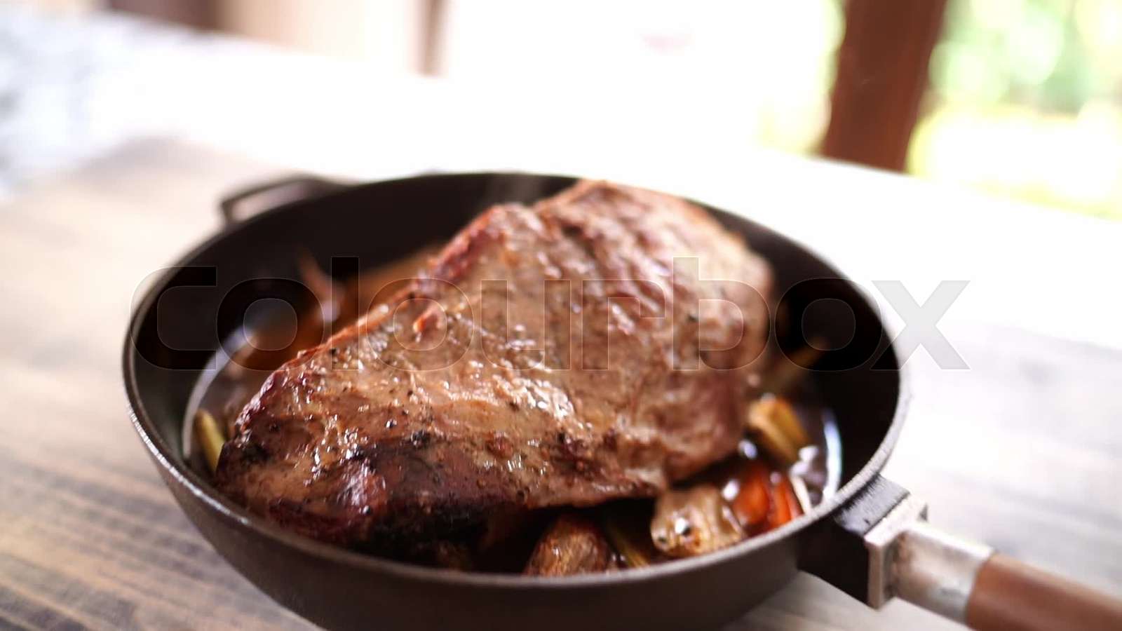 Steam rises over roast beef with vegetables lying in a pan | Stock ...