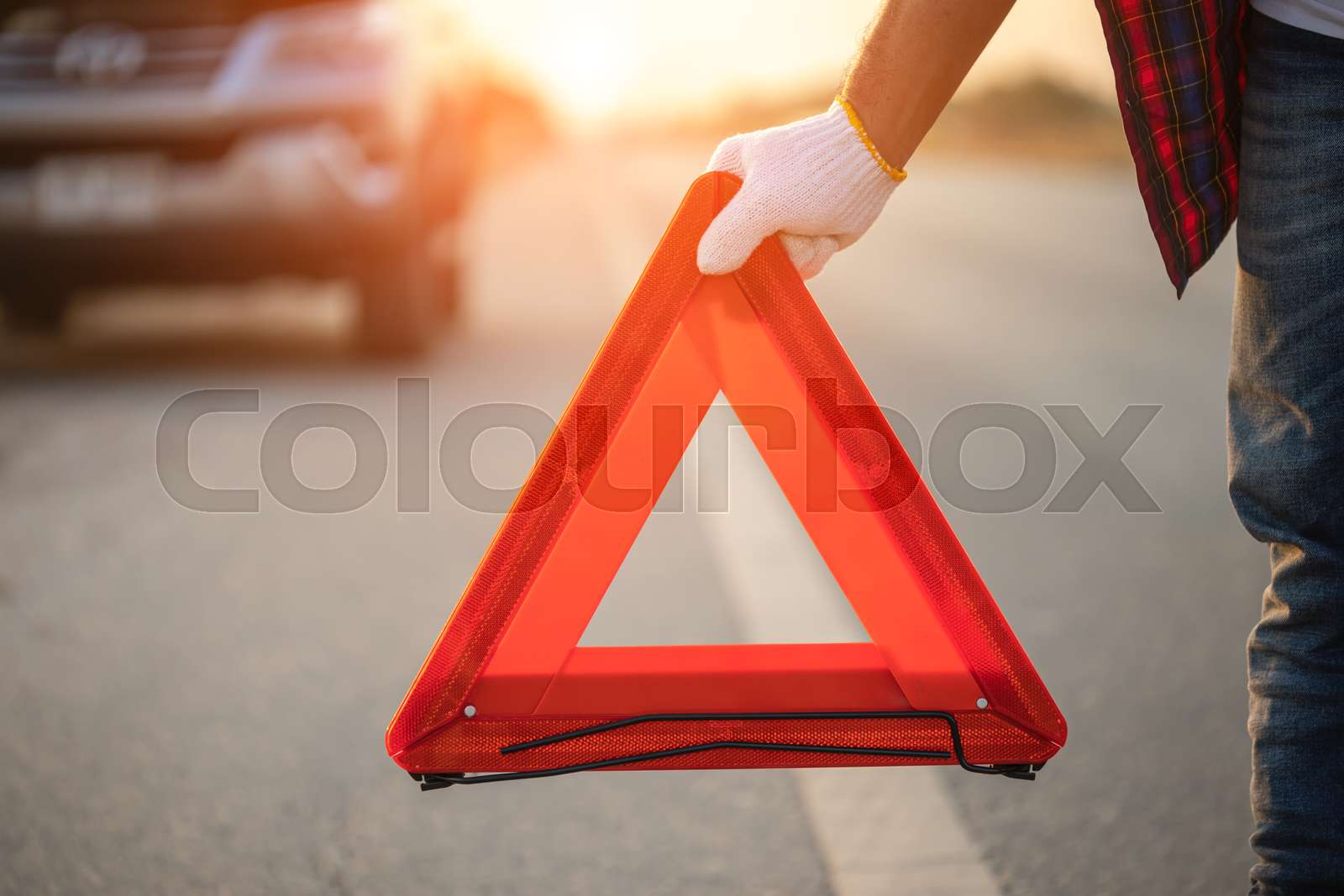 Man holding red emergency stop sign and put on the roadside. Car ...