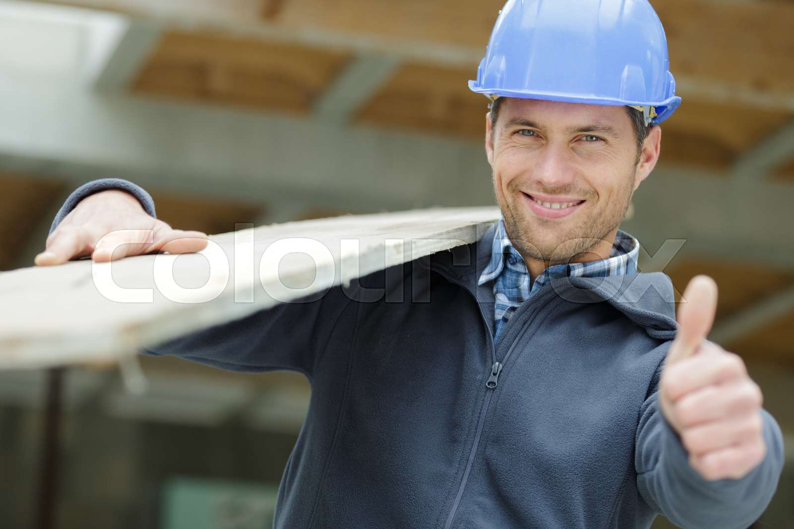 workman carrying wood on his shoulder and showing thumbs-up | Stock ...