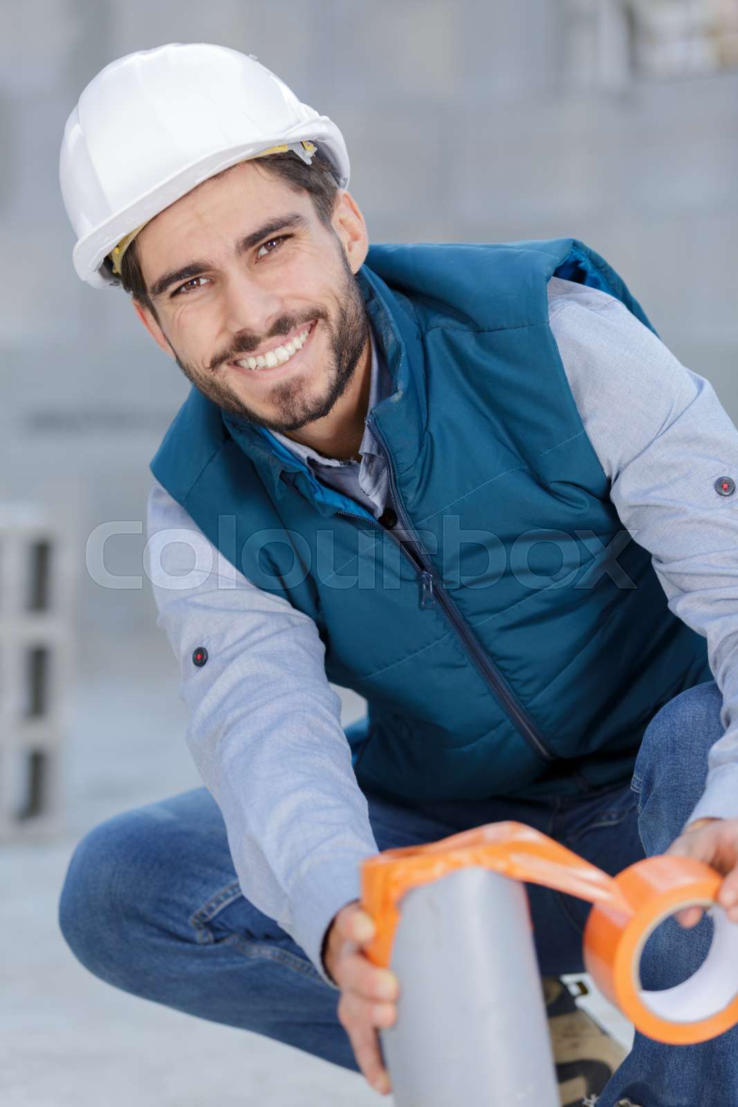 happy worker taping on plastic pipe | Stock image | Colourbox