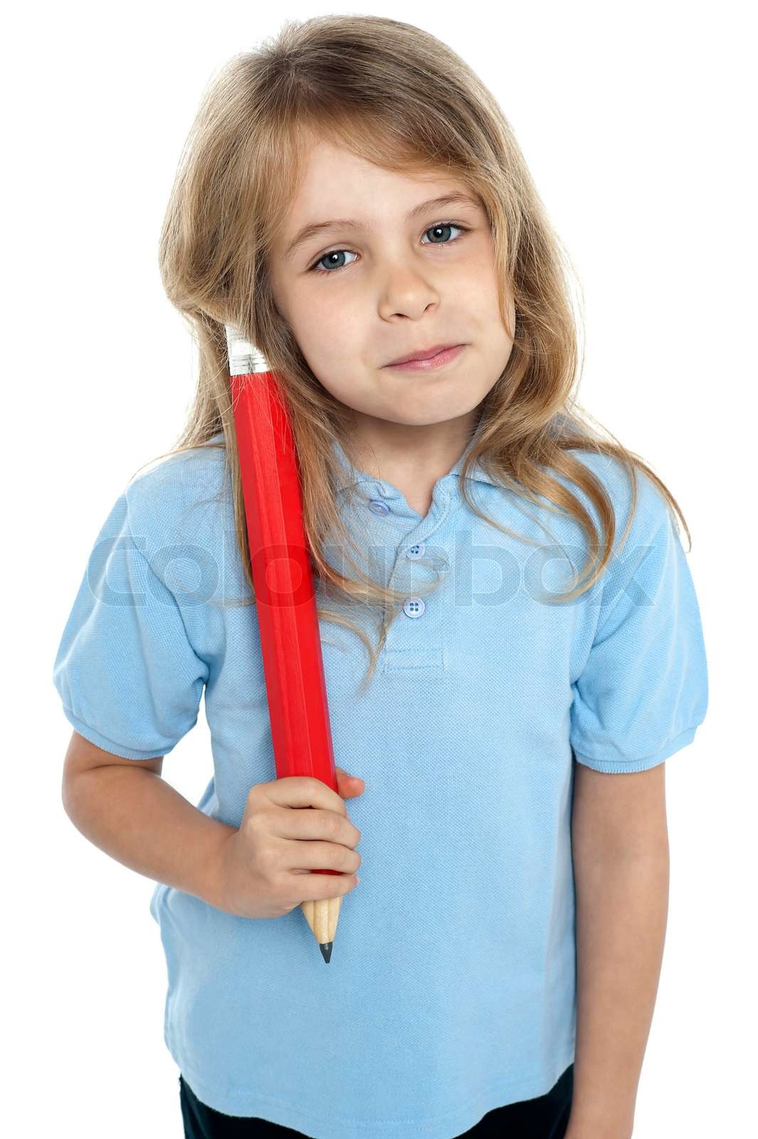 Straight faced kid holding huge red pencil | Stock image | Colourbox