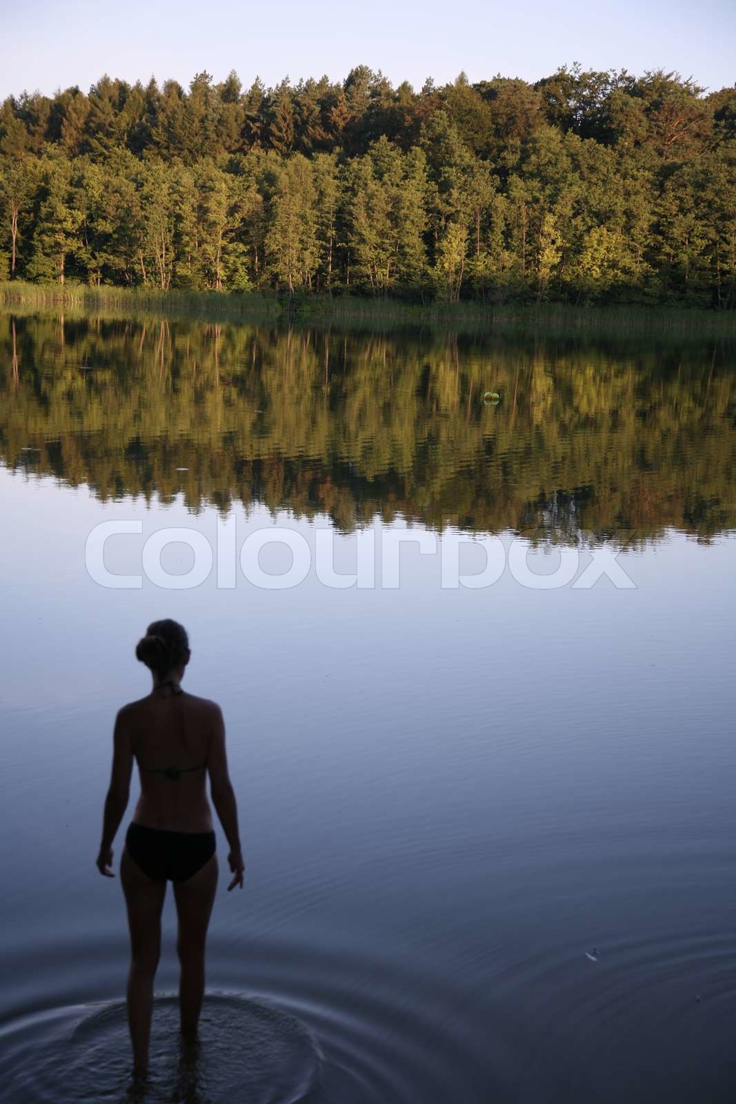Back of woman standing in bikini by riverside | Stock image | Colourbox