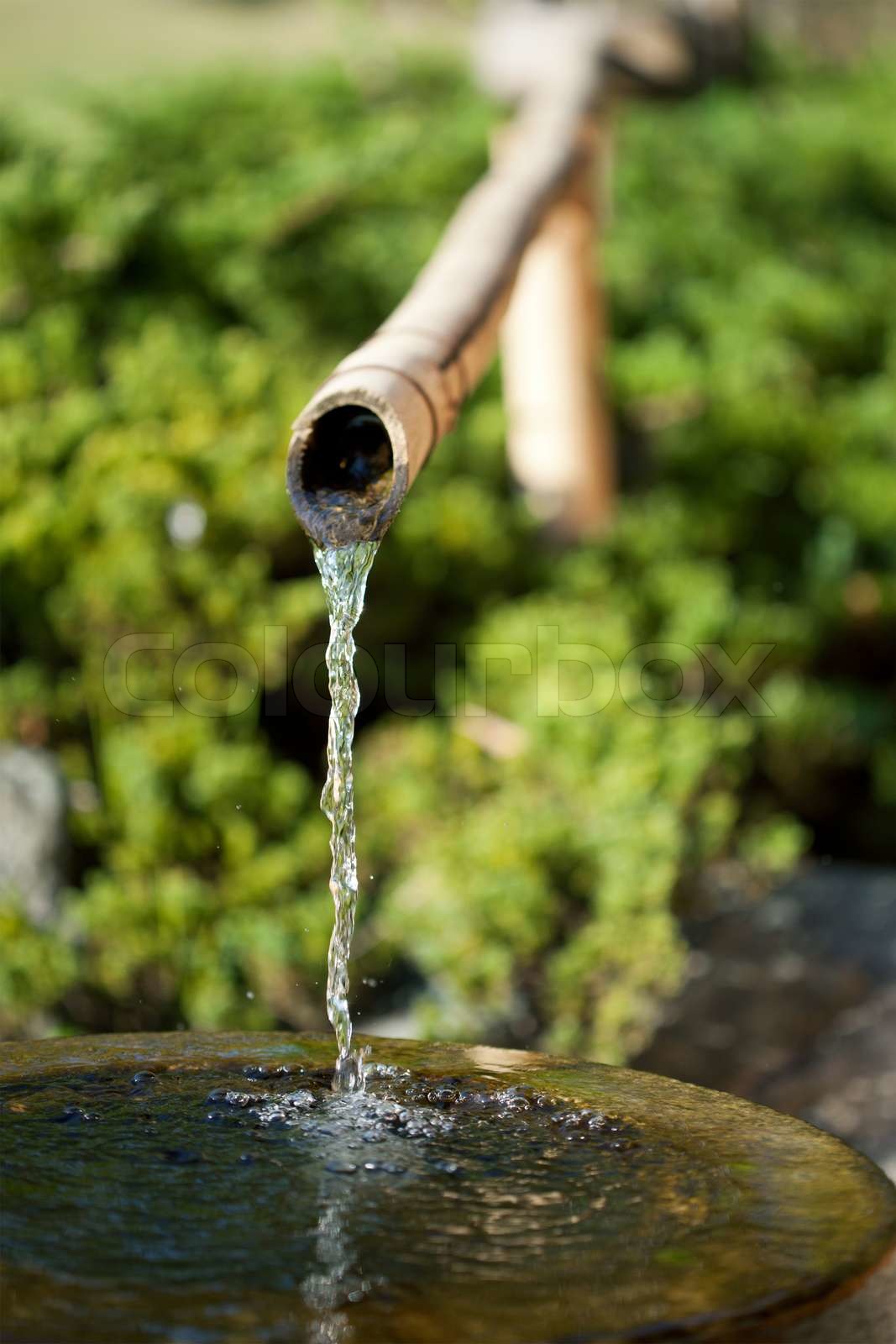 Bamboo tube and flowing water | Stock image | Colourbox