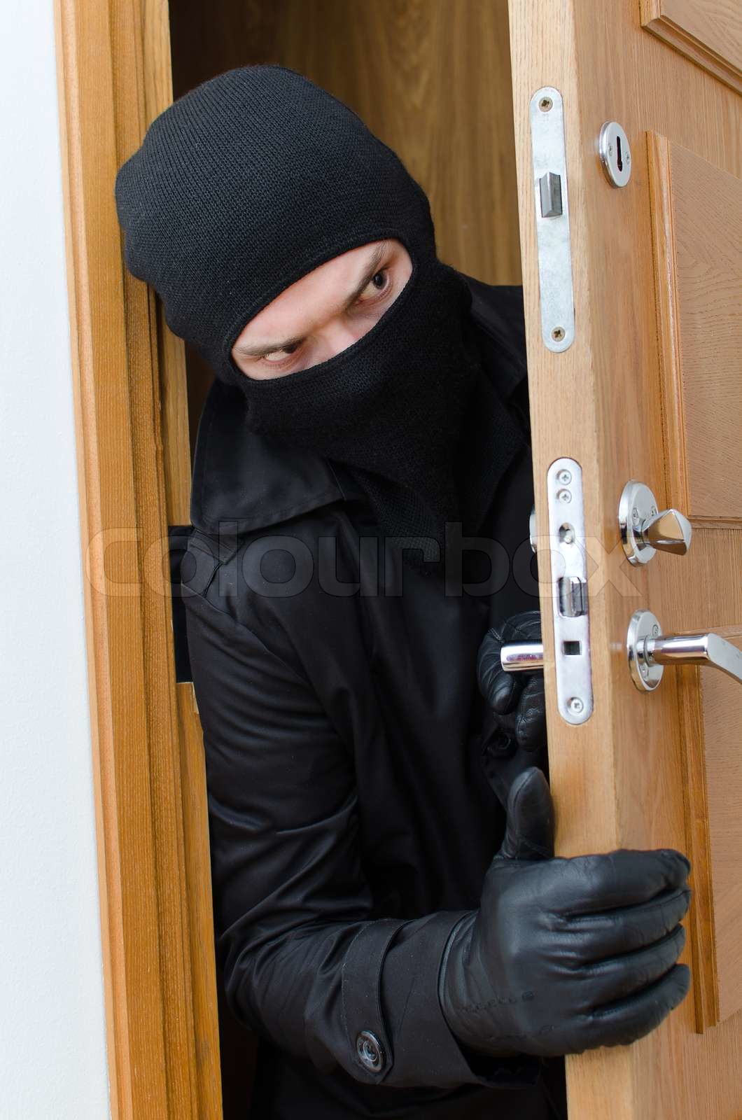 Male burglar in mask breaking into the house | Stock image | Colourbox