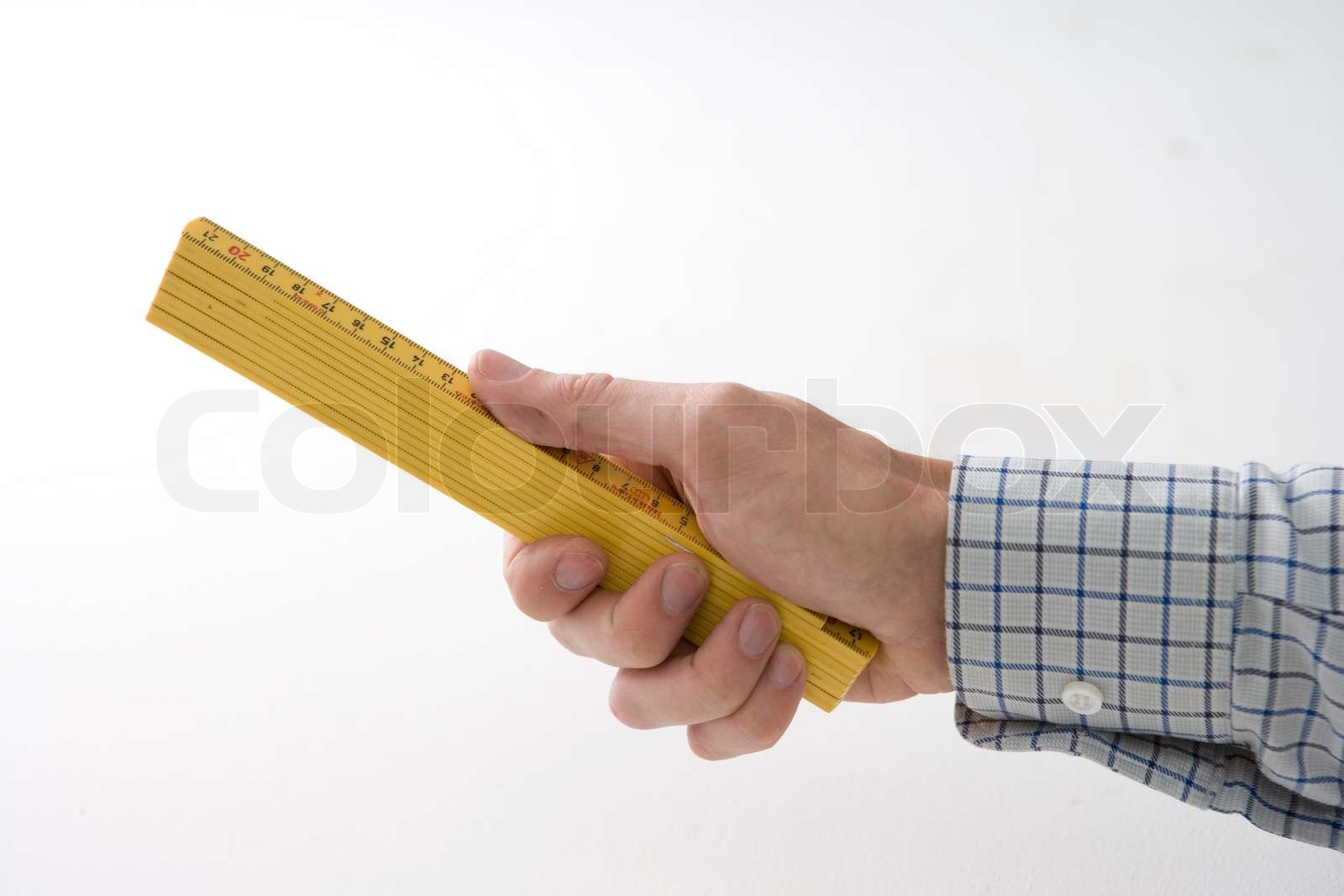 A man holding a wooden ruler | Stock image | Colourbox