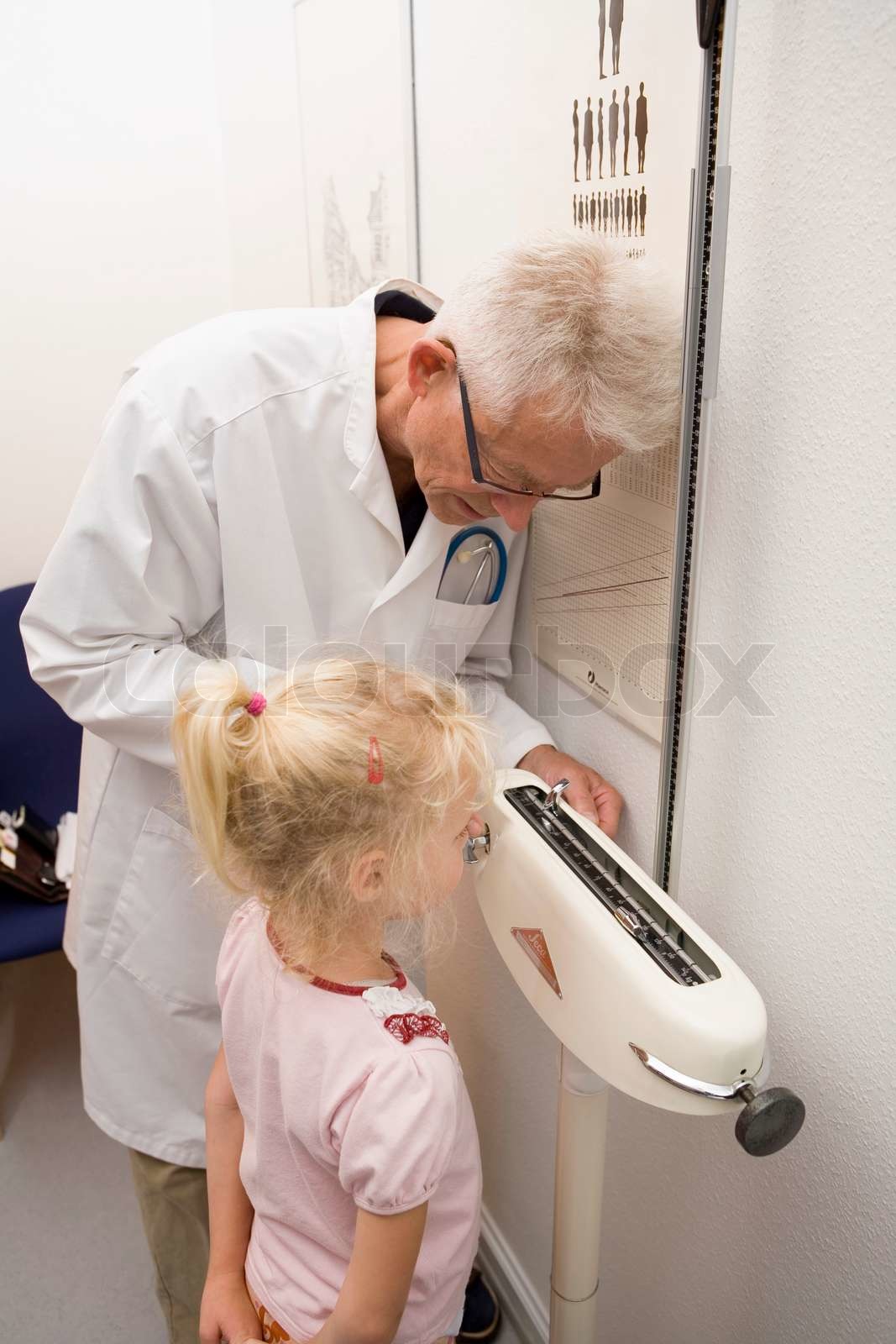 A doctor weighing a child on a scale | Stock image | Colourbox