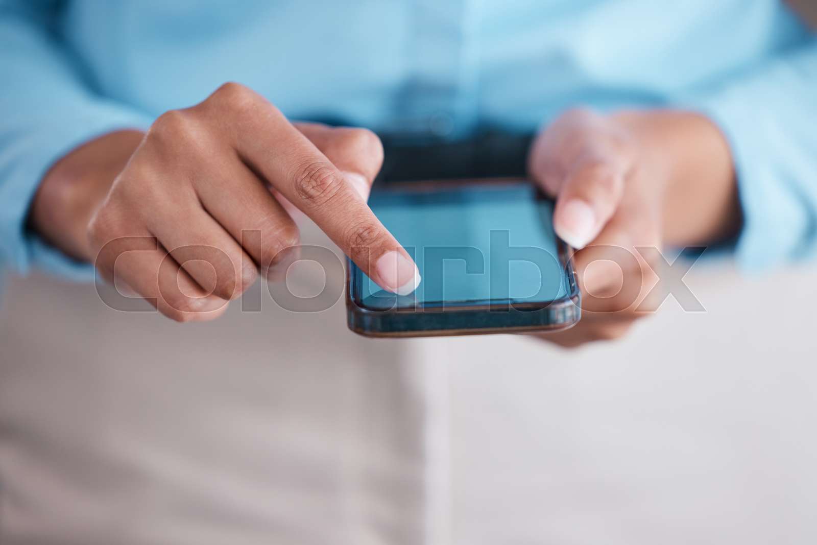 Closeup of female hands holding and and scrolling on smartphone while ...