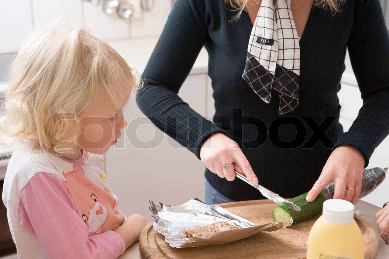 A caucasian girl and her mother making pack lunches | Stock image ...