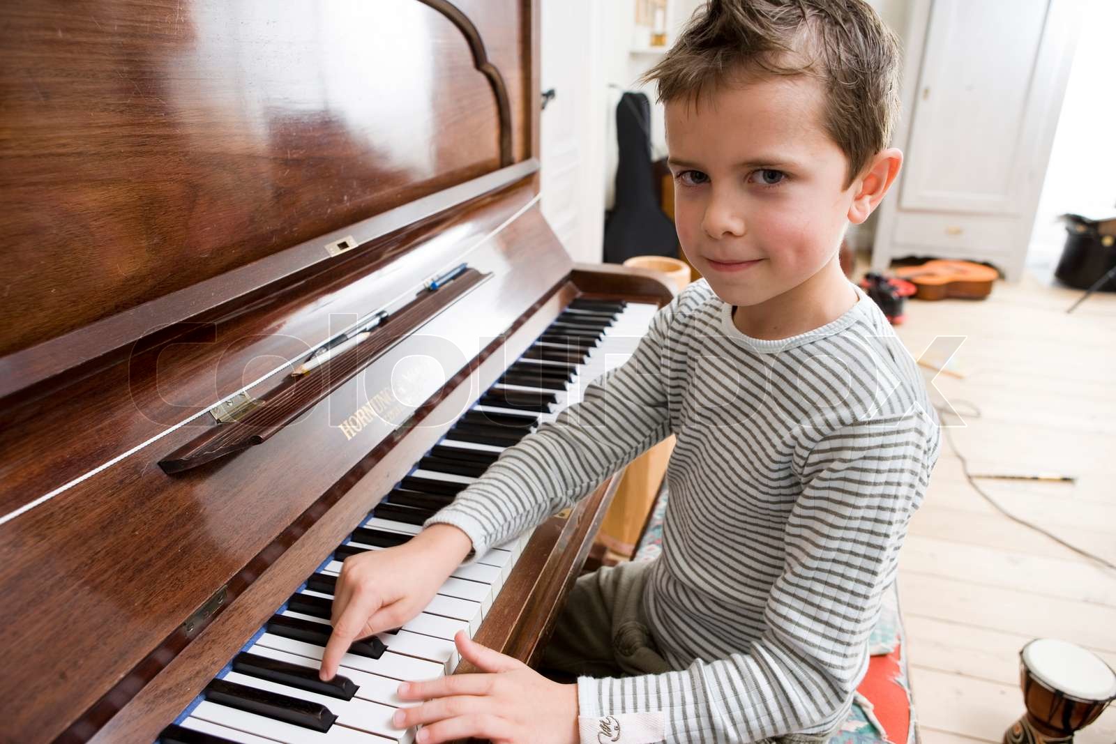 A young boy playing the piano | Stock image | Colourbox