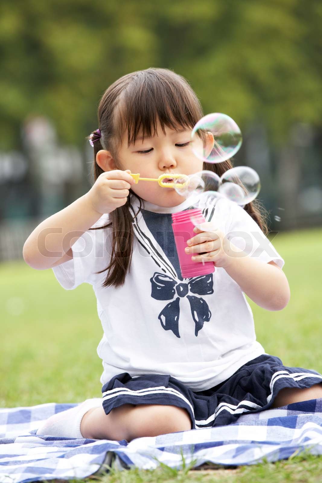Young Chinese Girl In Park Blowing Bubbles Stock Image Colourbox