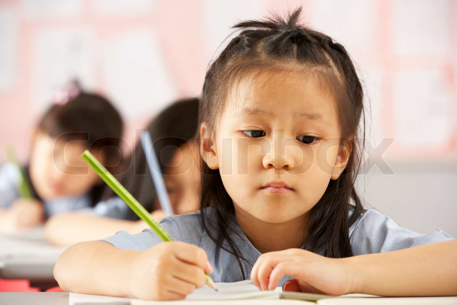 Group Of Students Working At Desks In Chinese School Classroom | Stock ...