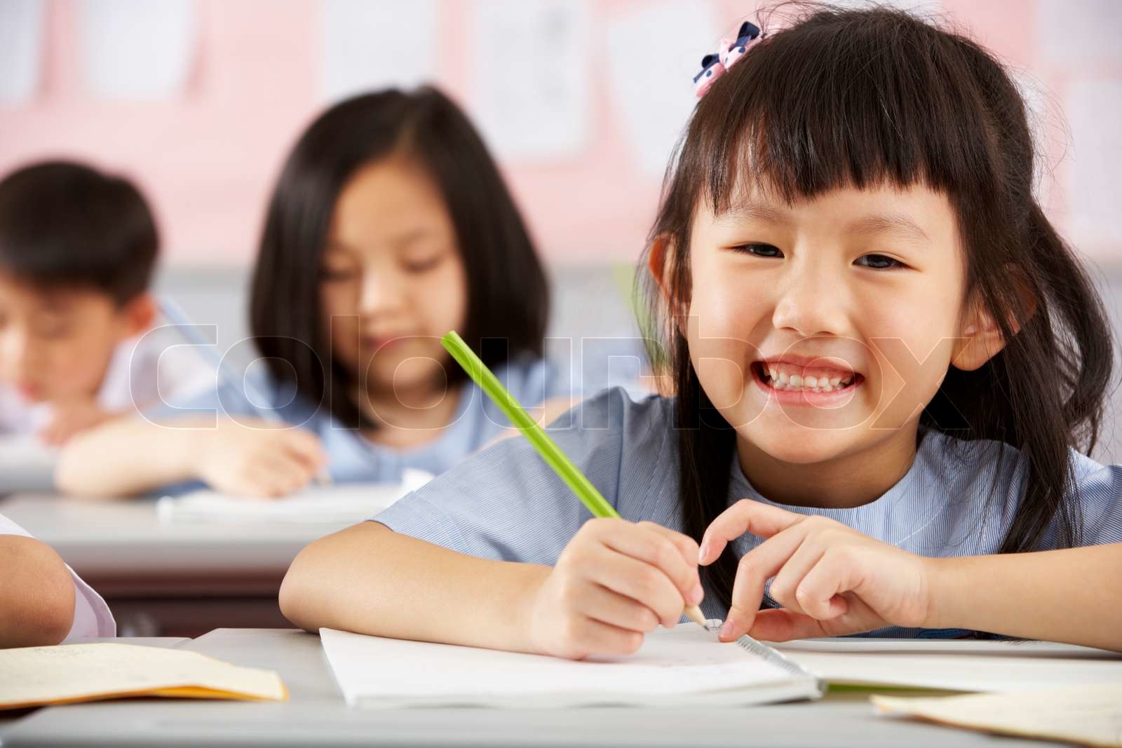 Group Of Students Working At Desks In Chinese School Classroom | Stock ...