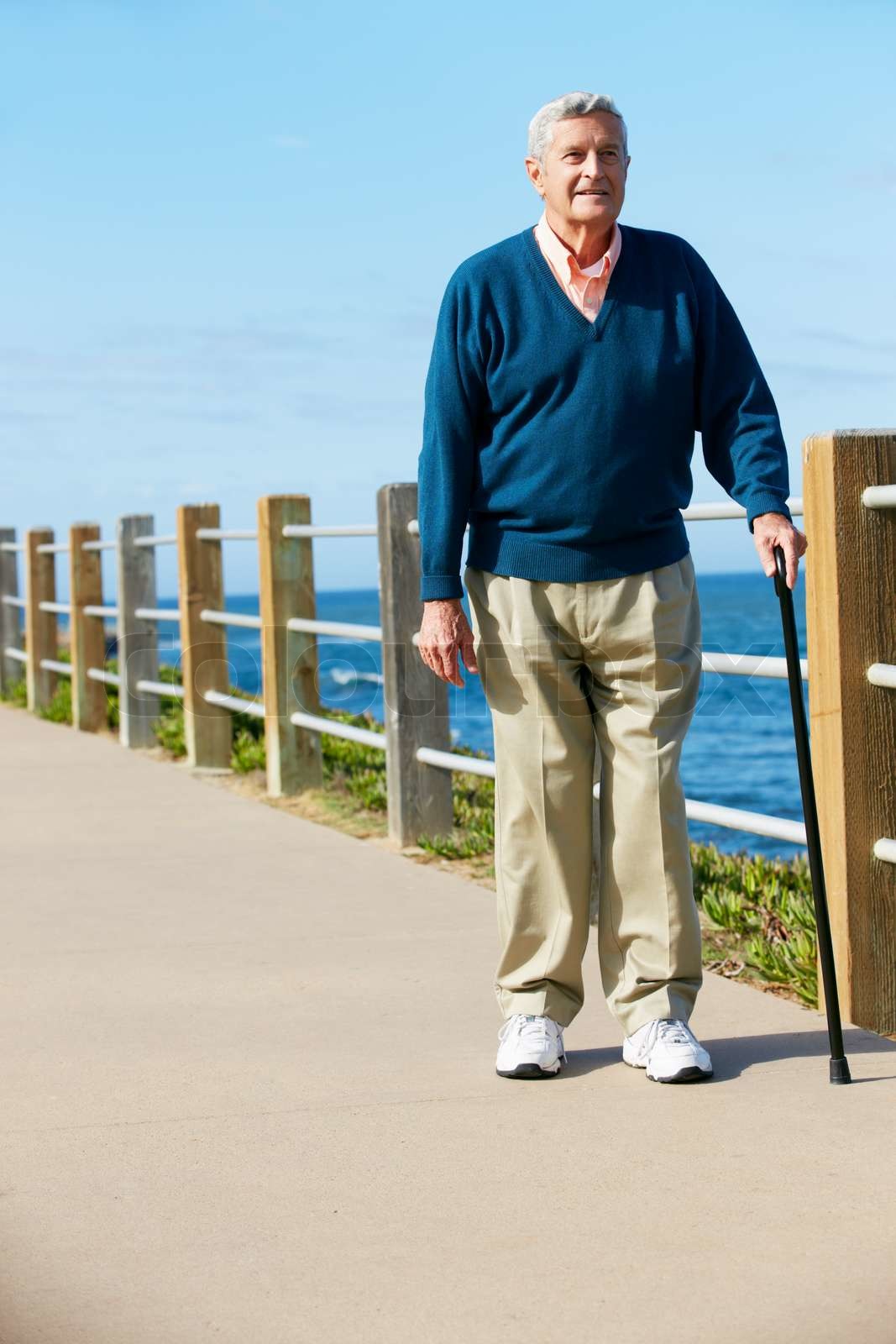 Senior Man Walking Along Path By The Sea | Stock image | Colourbox