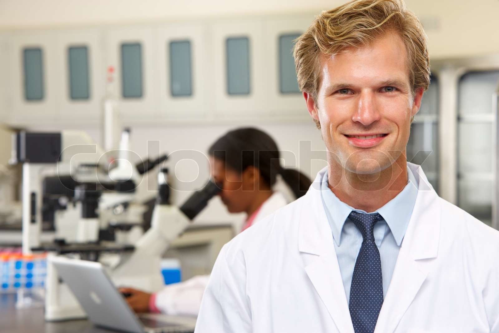 Male And Female Scientists Using Microscopes In Laboratory | Stock ...
