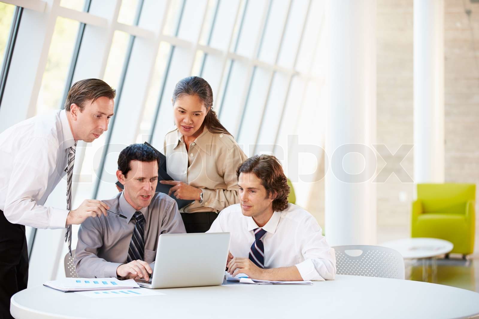 Businesspeople Having Meeting Around Table In Modern Office | Stock ...