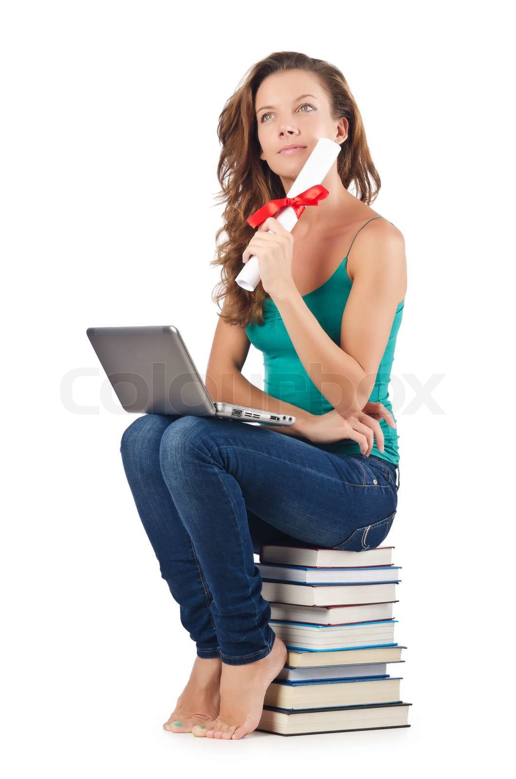Student with netbook sitting on books | Stock image | Colourbox