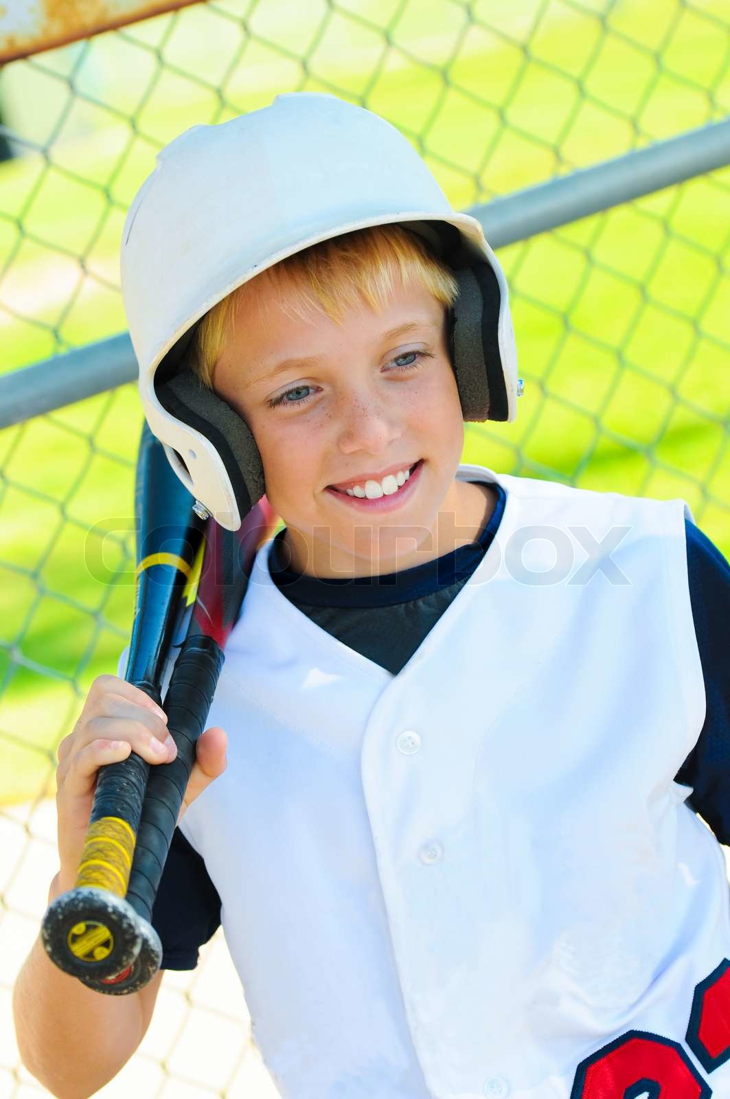 Cute baseball player in dugout | Stock image | Colourbox