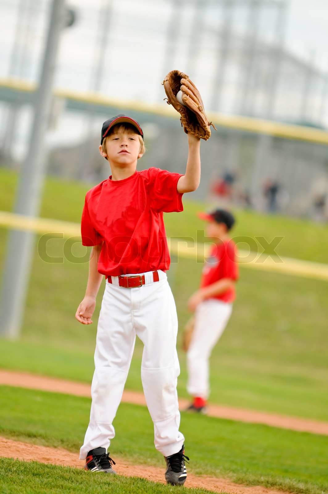 Youth baseball pitcher in red jersey | Stock image | Colourbox