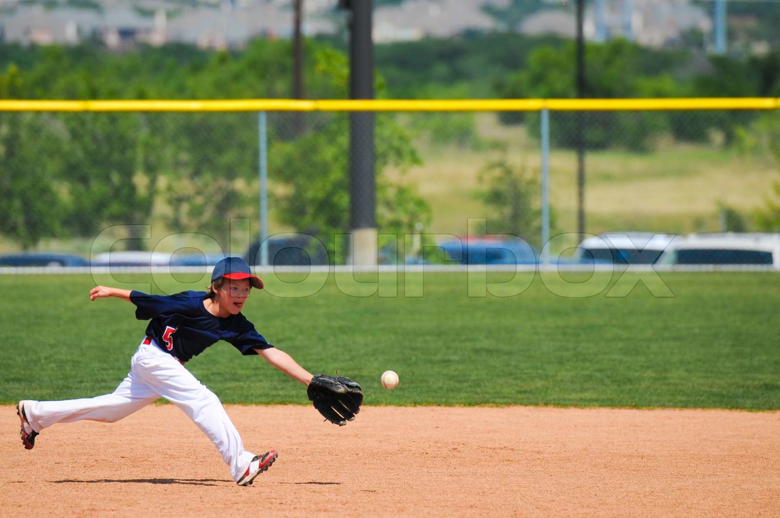 Little league boy reach out to catch ball | Stock image | Colourbox