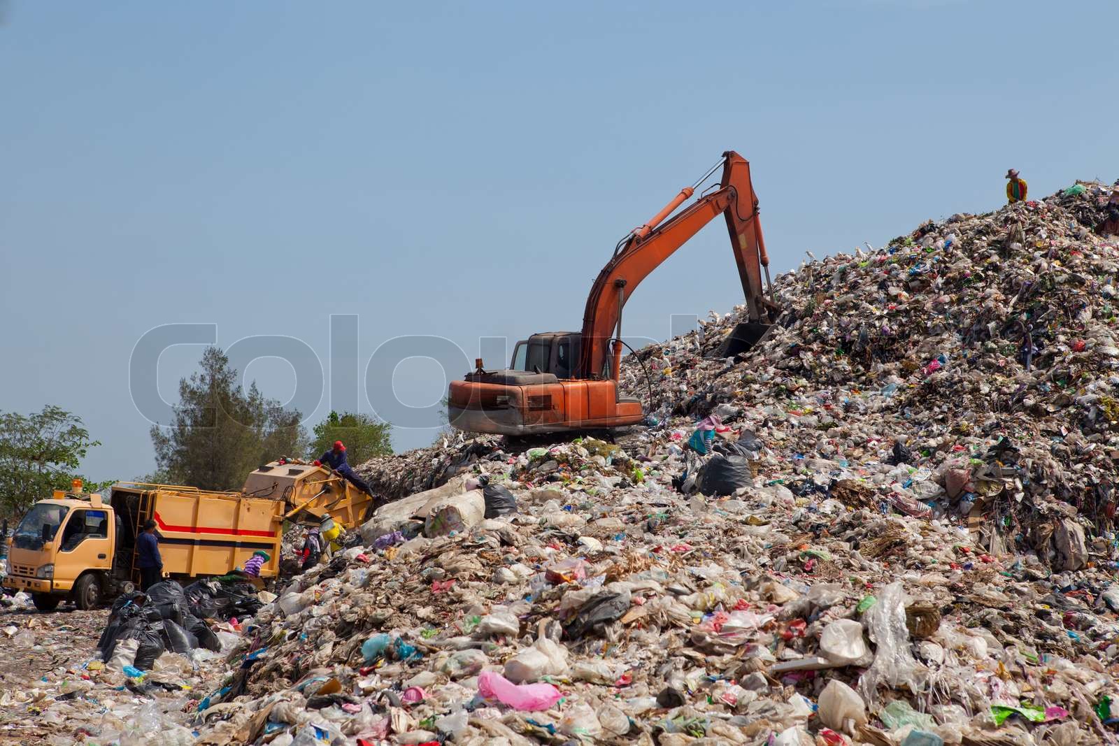 Backhoe moves trash in a landfill site, pollution, Global warming ...