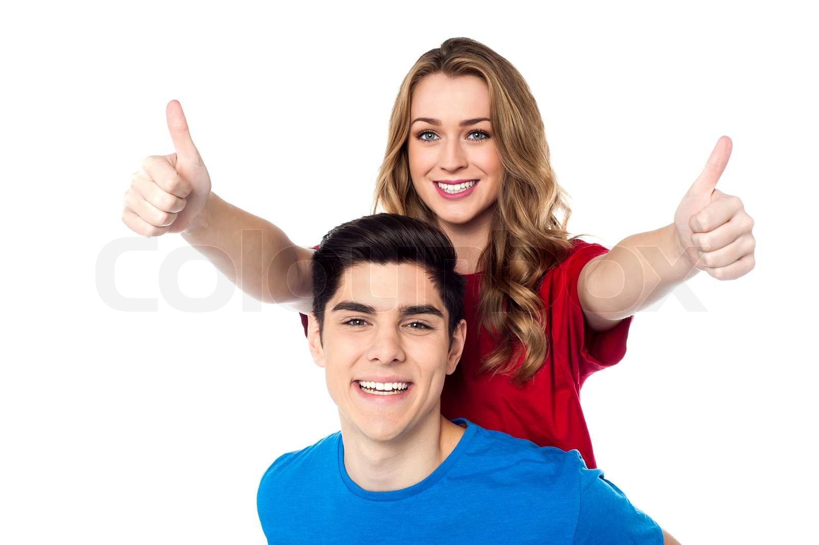 Joyous woman enjoying piggy ride and showing double thumbs up | Stock ...