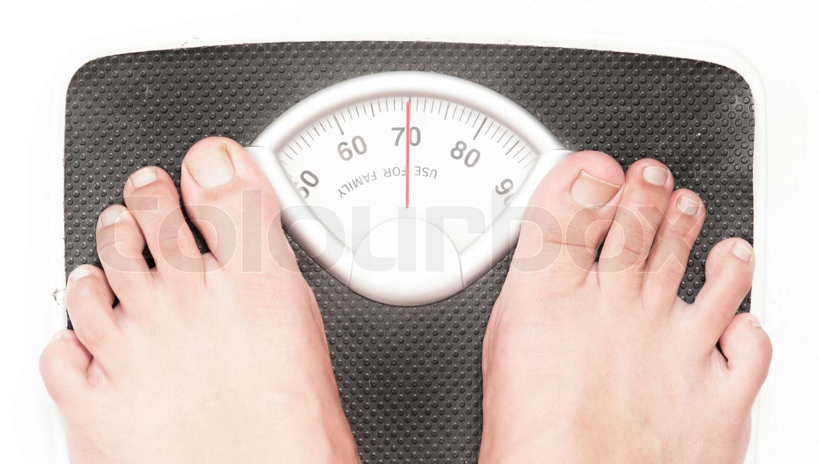 Feet on scales isolated on white | Stock image | Colourbox