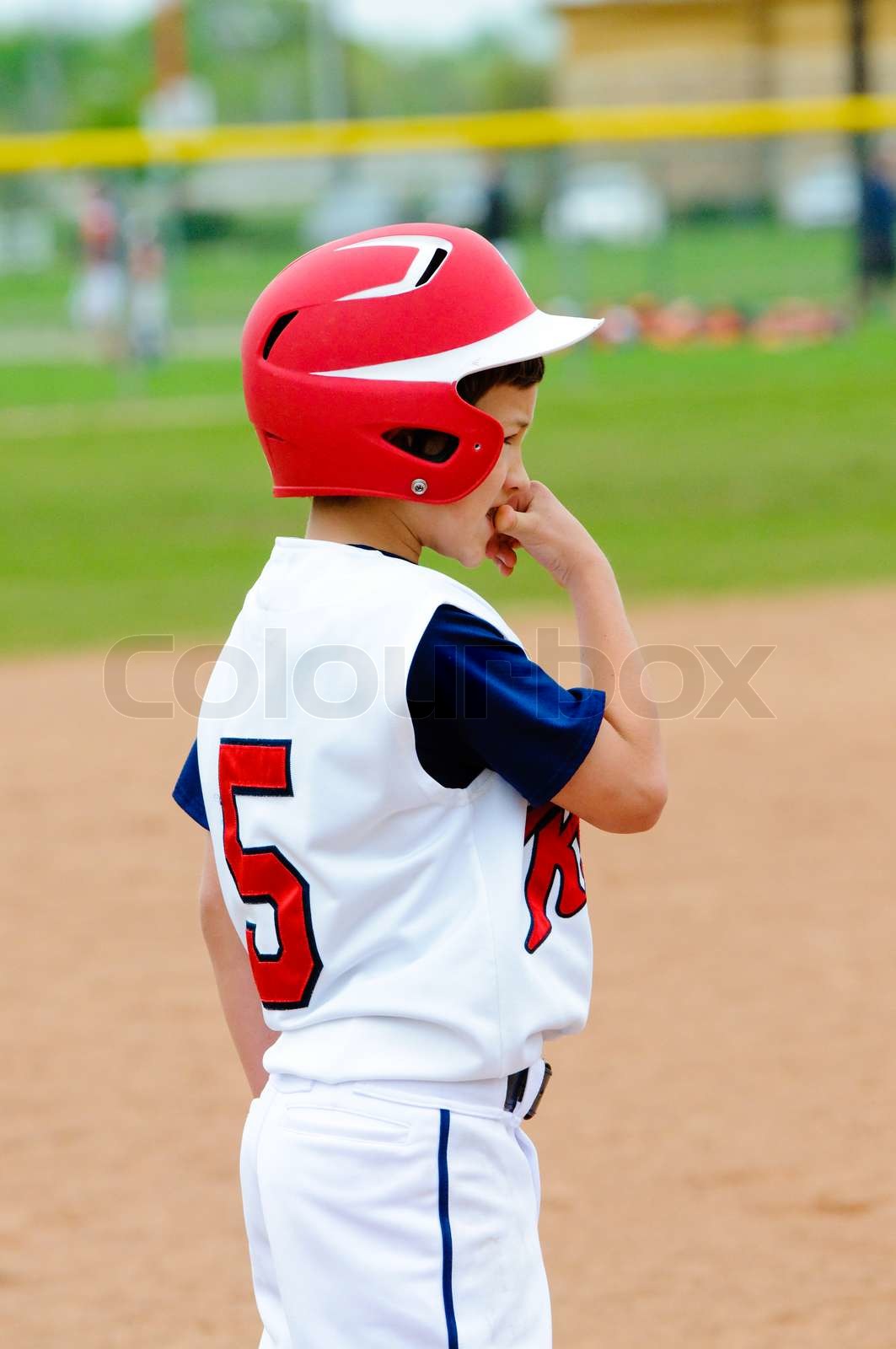 Little league player on base | Stock image | Colourbox