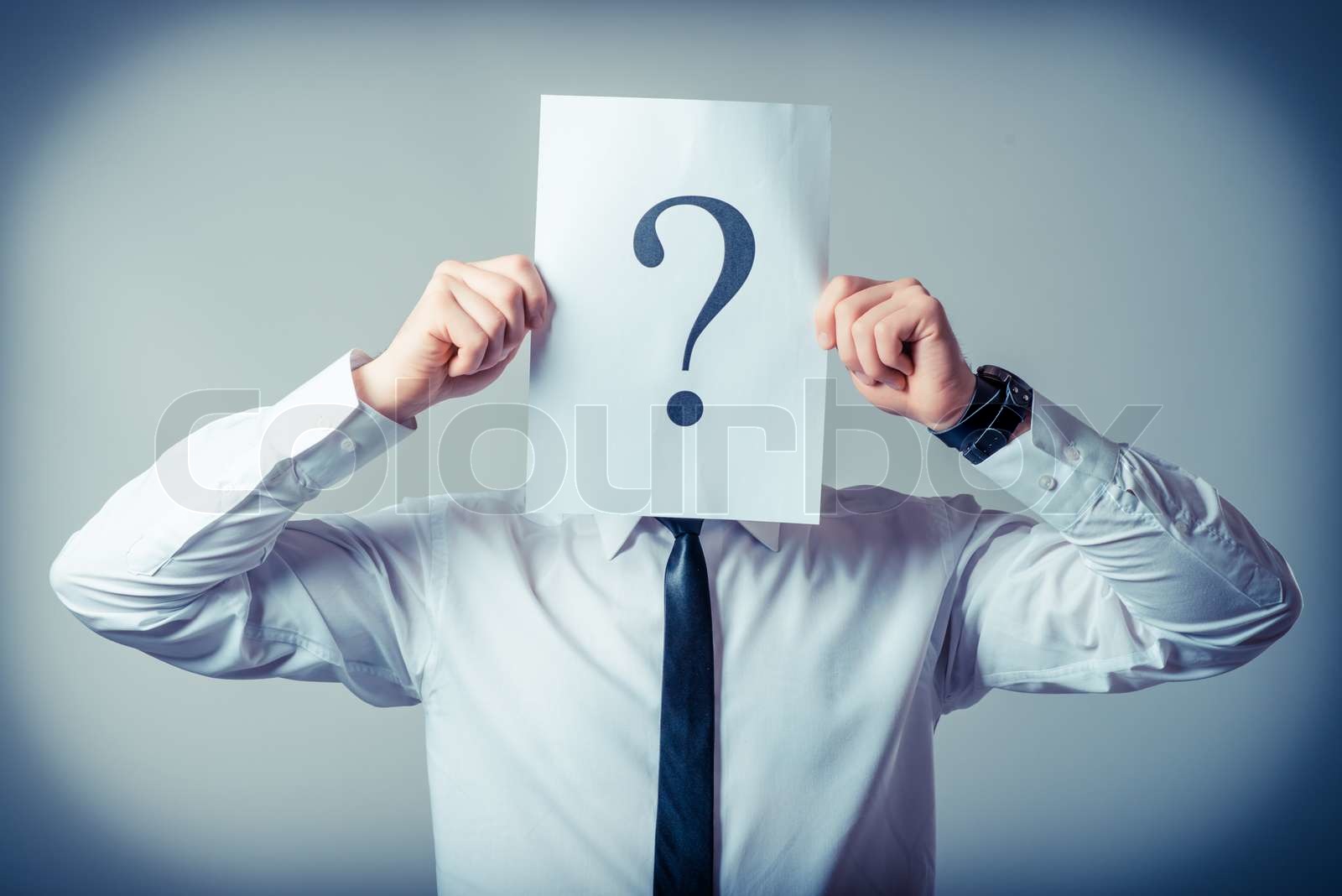 Young businessman holding a white billboard with a question mark on it ...