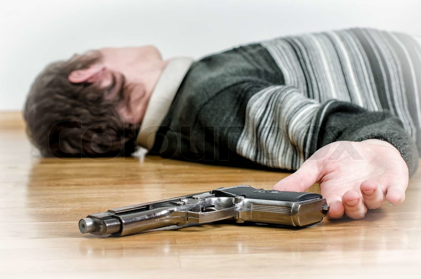 Man with gun laying on the floor | Stock image | Colourbox