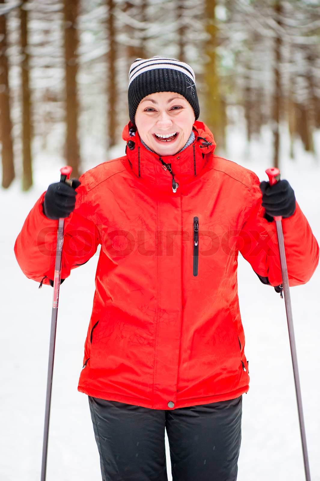 Glad pige poserer på ski i vinter skoven | Stock foto | Colourbox