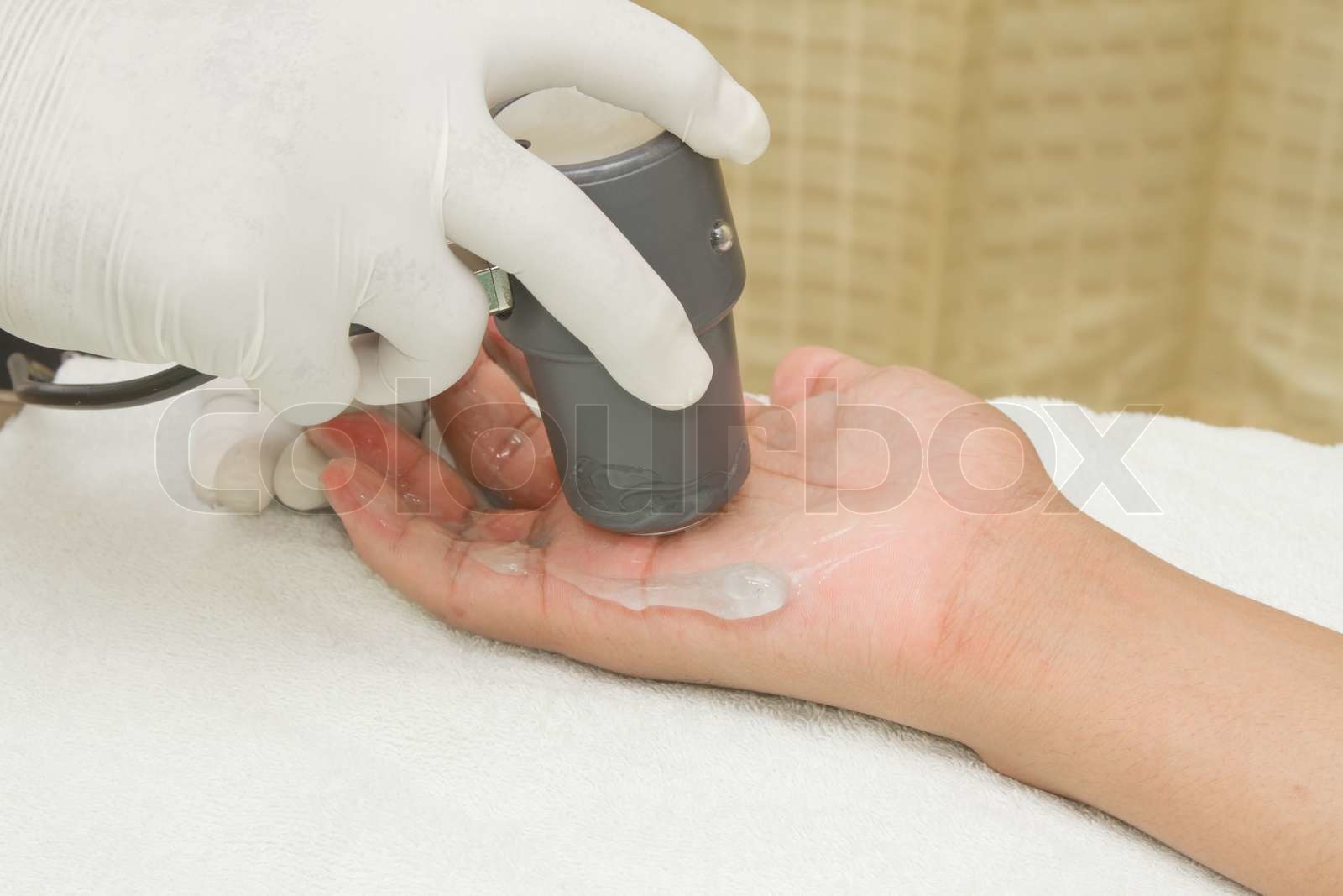 Physiotherapist is applying ultrasound therapy on the hand with ...