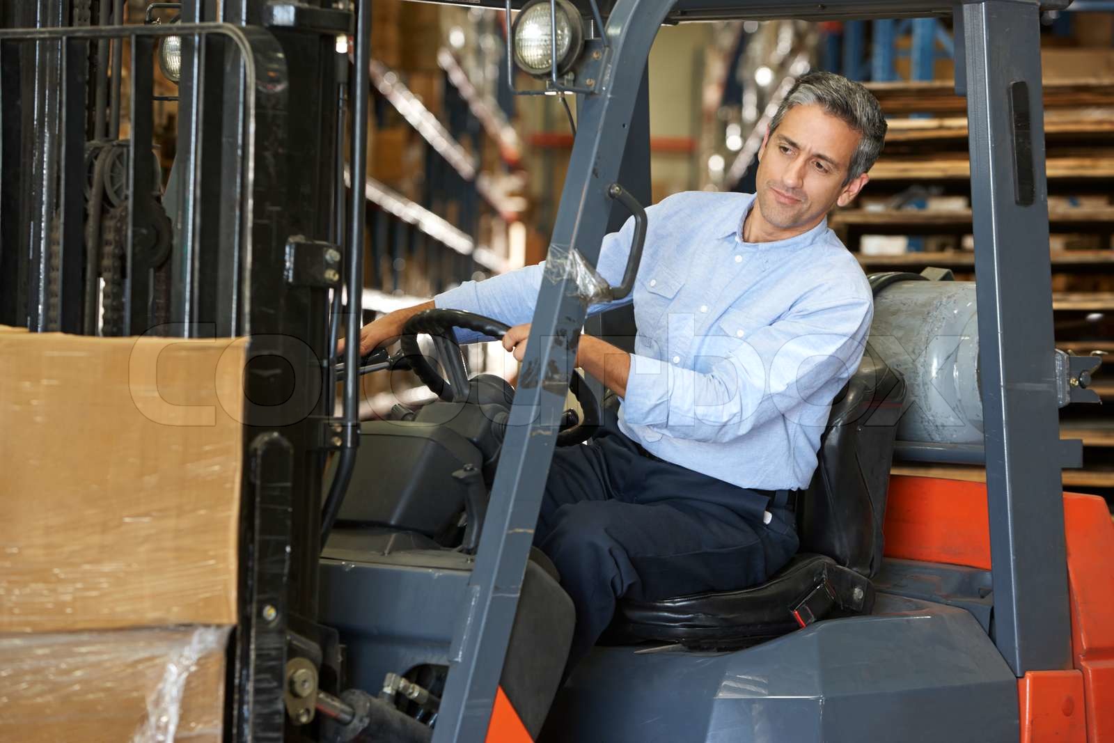 Man Driving Fork Lift Truck In Warehouse | Stock image | Colourbox