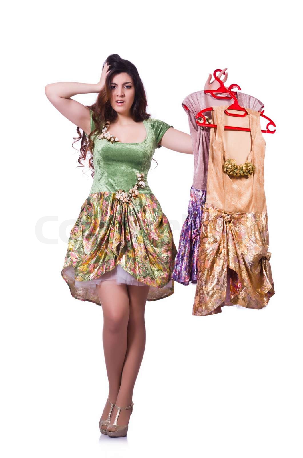 Woman trying to choose dress on white | Stock image | Colourbox
