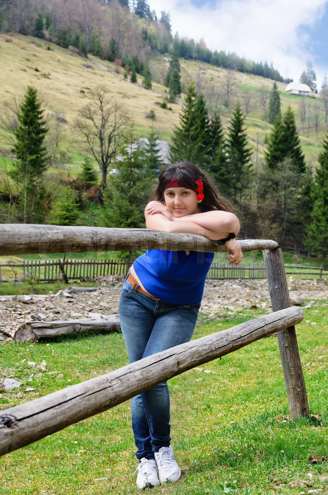 Pretty woman leaning on a rustic fence | Stock image | Colourbox