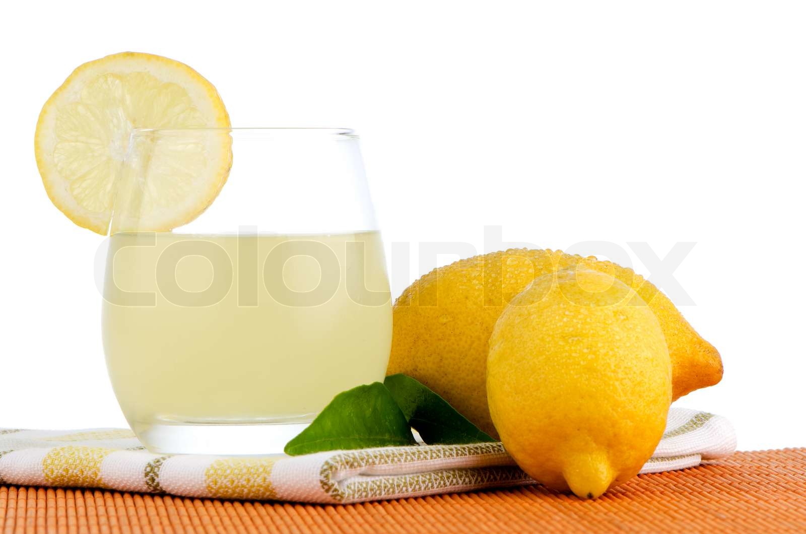 Cup of lemon juice and fresh lemons | Stock image | Colourbox