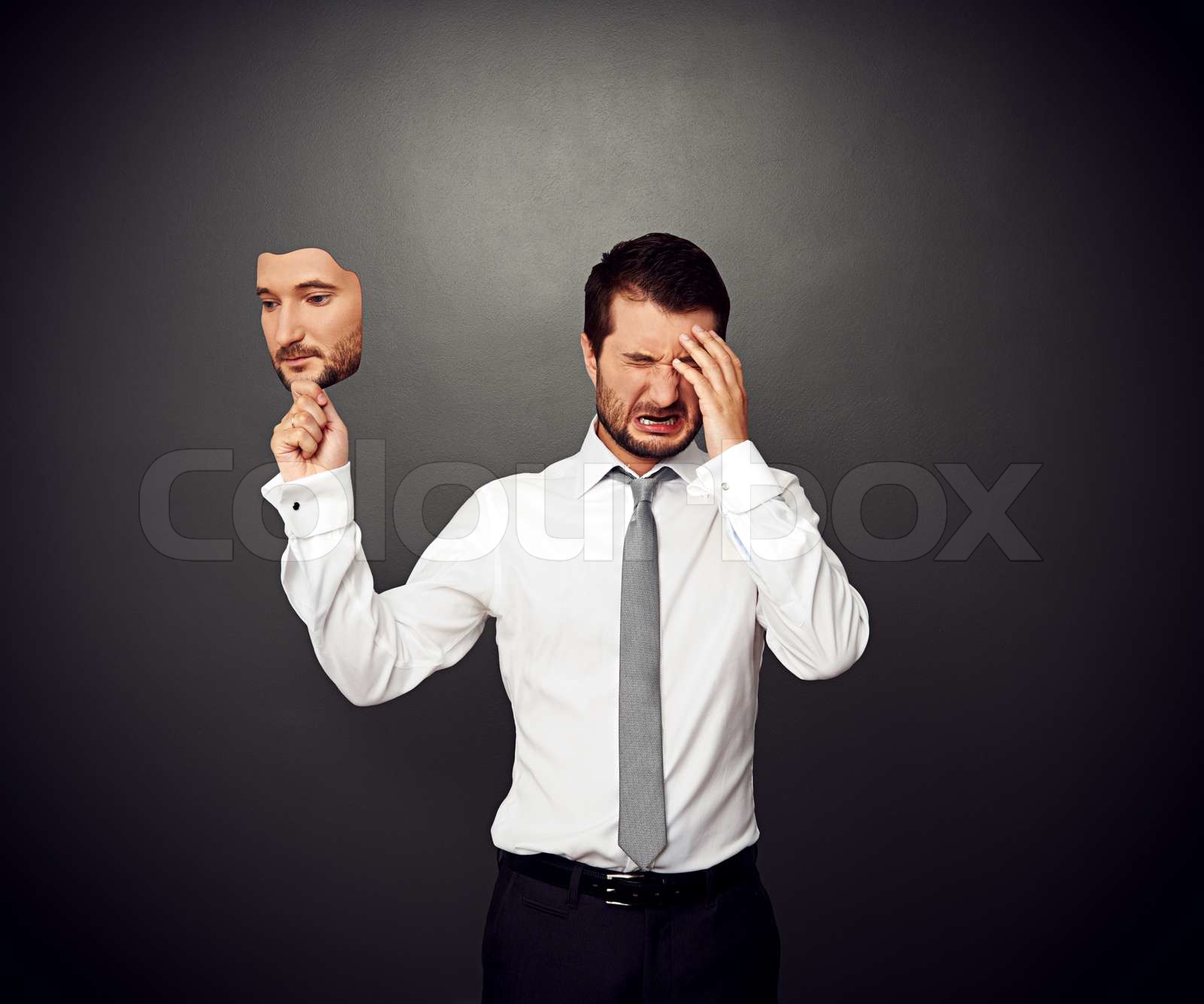 man holding mask with serious face | Stock image | Colourbox