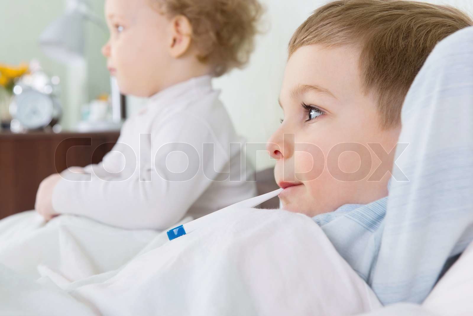 Little girl and her sick brother lying in bed | Stock image | Colourbox