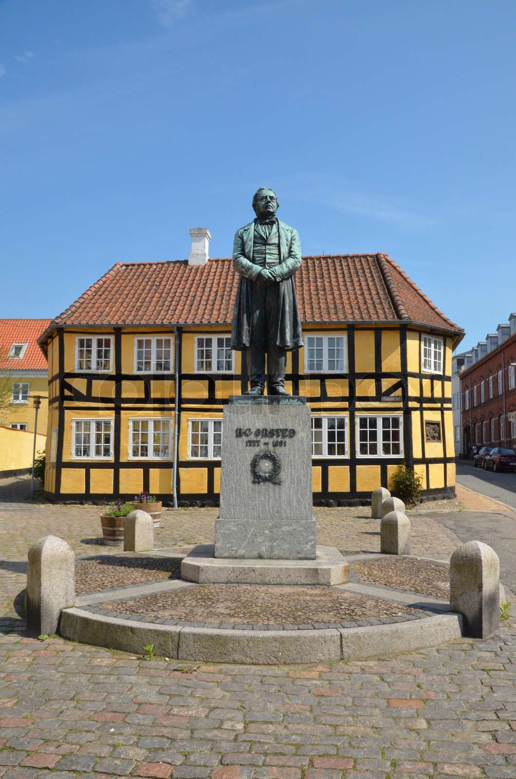 torv i Rudkøbing med statue af HC Ørsted og gammelt gult bindingsværks ...