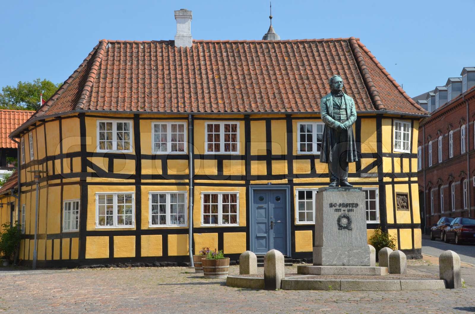 torv i Rudkøbing med statue af HC Ørsted og gammelt gult bindingsværks ...